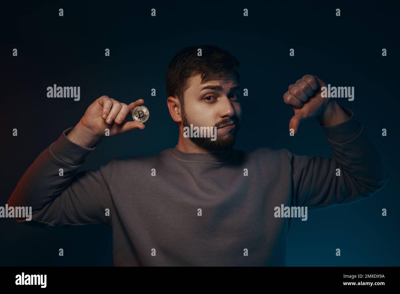 Bitcoin is a scam. Man shows finger down Stock Photo - Alamy