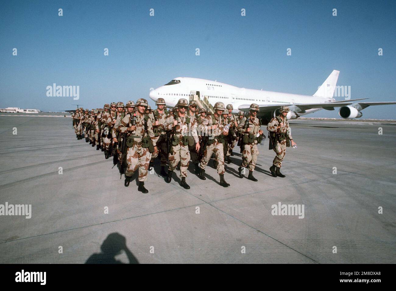 Troops march in formation after disembarking from a Civil Reserve Air Fleet (CRAF) Boeing 747 ...