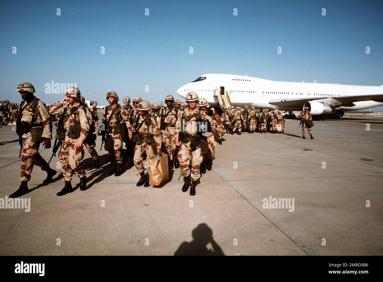 Troops assemble on the airfield after arriving aboard a Civil Reserve ...