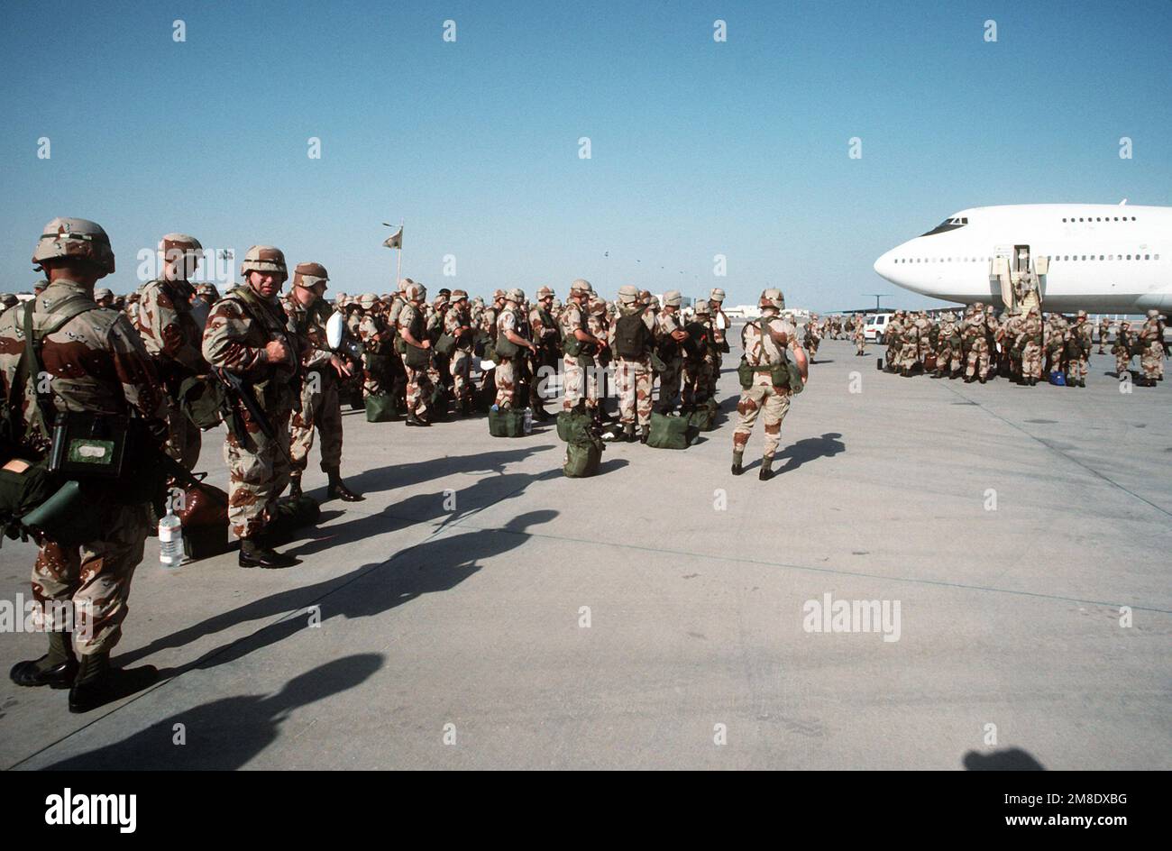 Troops assemble on the airfield after arriving aboard a Civil Reserve ...