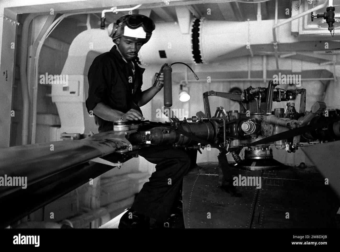 A maintenance crew member does repair work on a Helicopter Light Anti ...