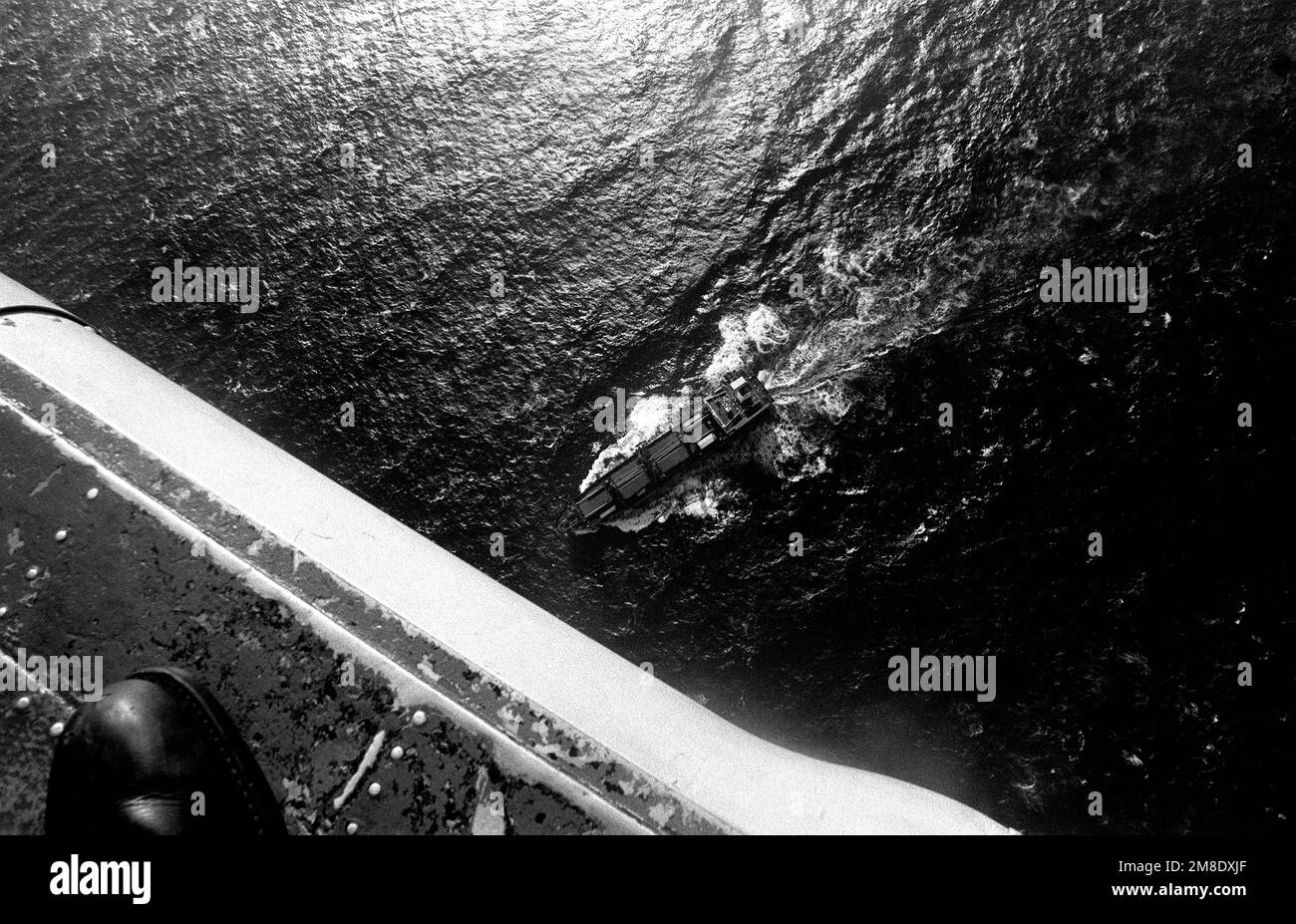 A container ship passes beneath a hovering Helicopter Light Anti ...