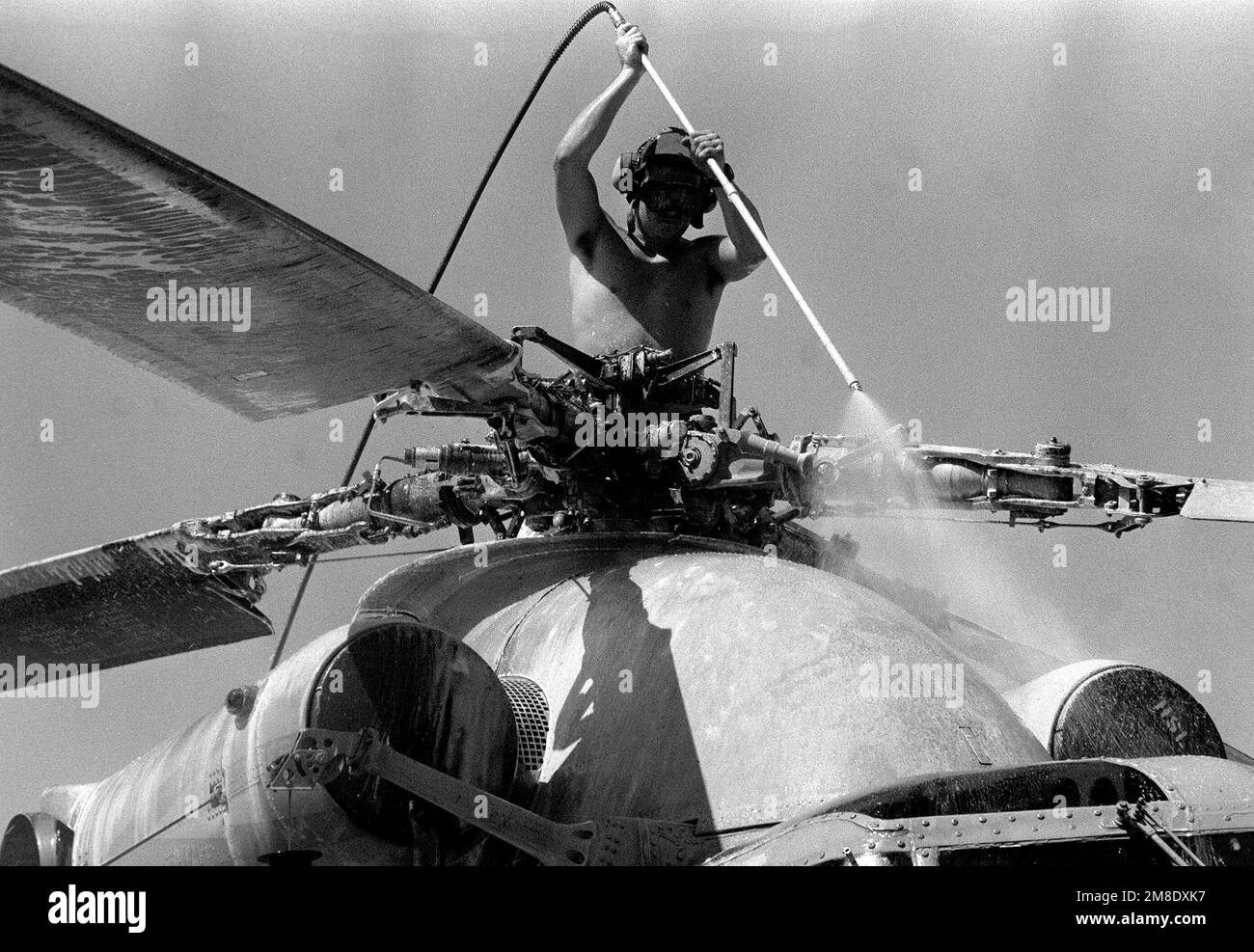 A squadron member hoses down a Helicopter Light Anti-submarine Squadron ...