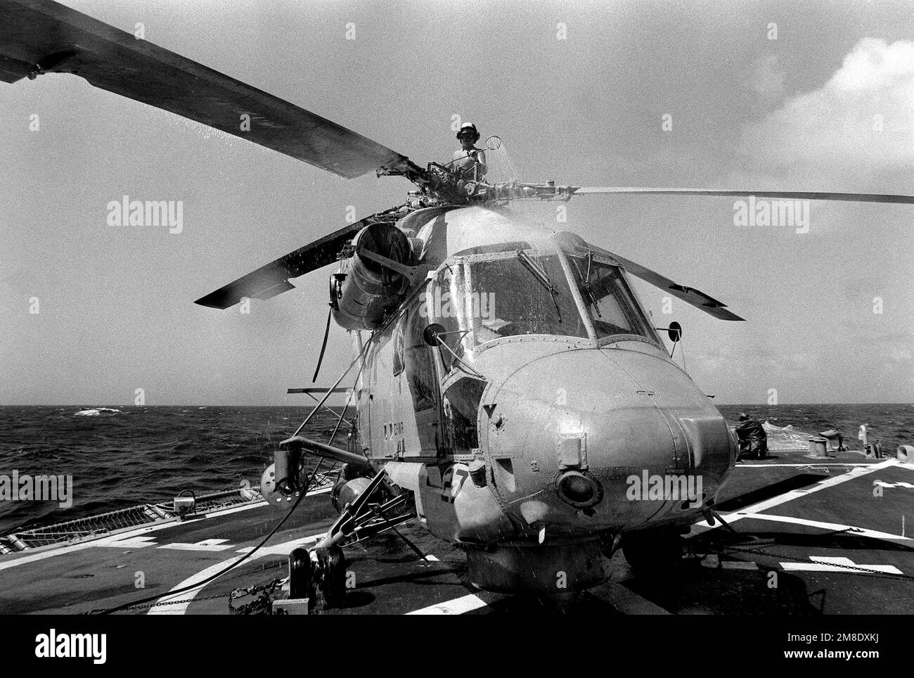 A squadron member hoses down a Helicopter Light Anti-submarine Squadron ...