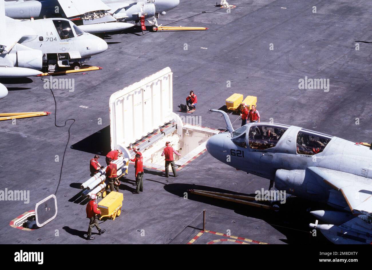 Four aviation ordnancemen work on a load of AIM-7 Sparrow III missiles ...