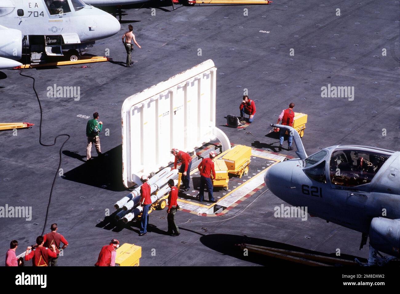 Aviation ordnancemen move several Aero 12C bomb skids and a weapons ...