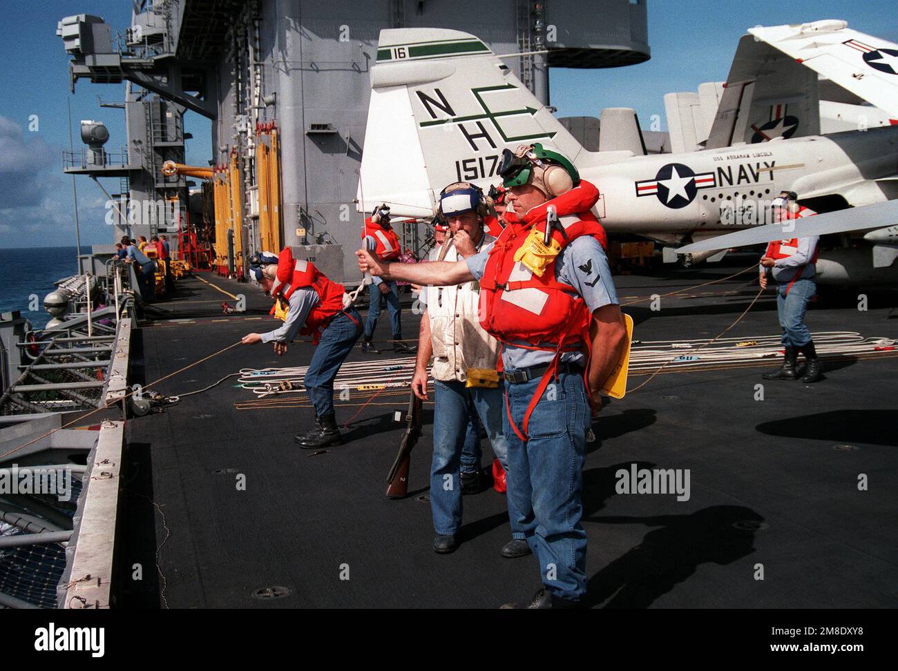 A crew member aboard the nuclear-powered aircraft carrier USS ABRAHAM ...