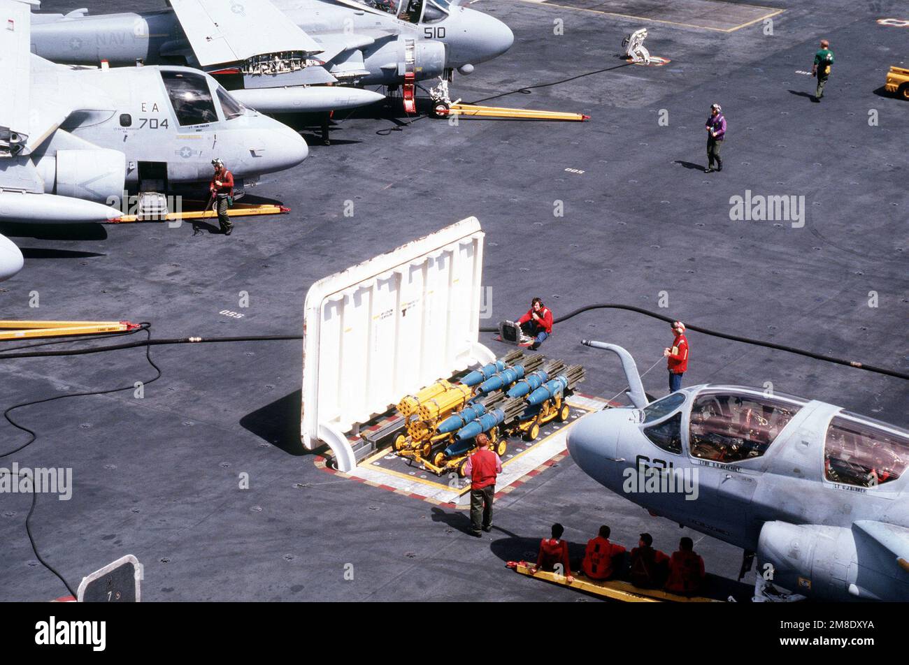 Aviation ordnancemen stand by to remove Aero 21A weapons skids loaded ...
