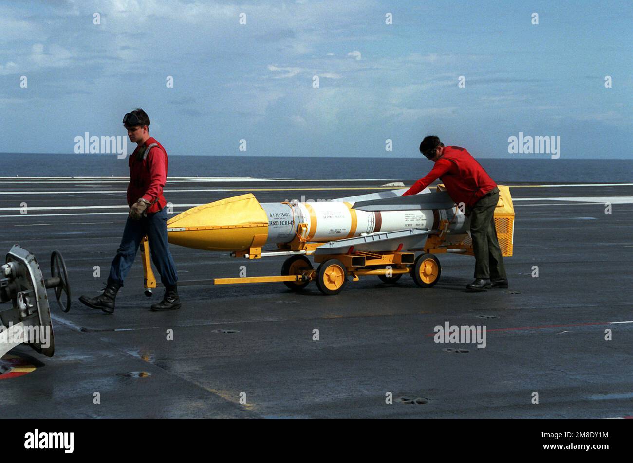 Ordnance crew members use an Aero 21A weapons skid to transport an AIM ...