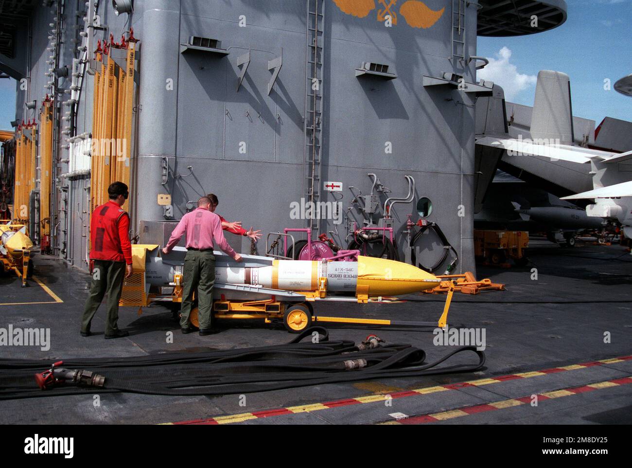 A fuel technician and an ordnance crew member inspect an AIM-54C ...