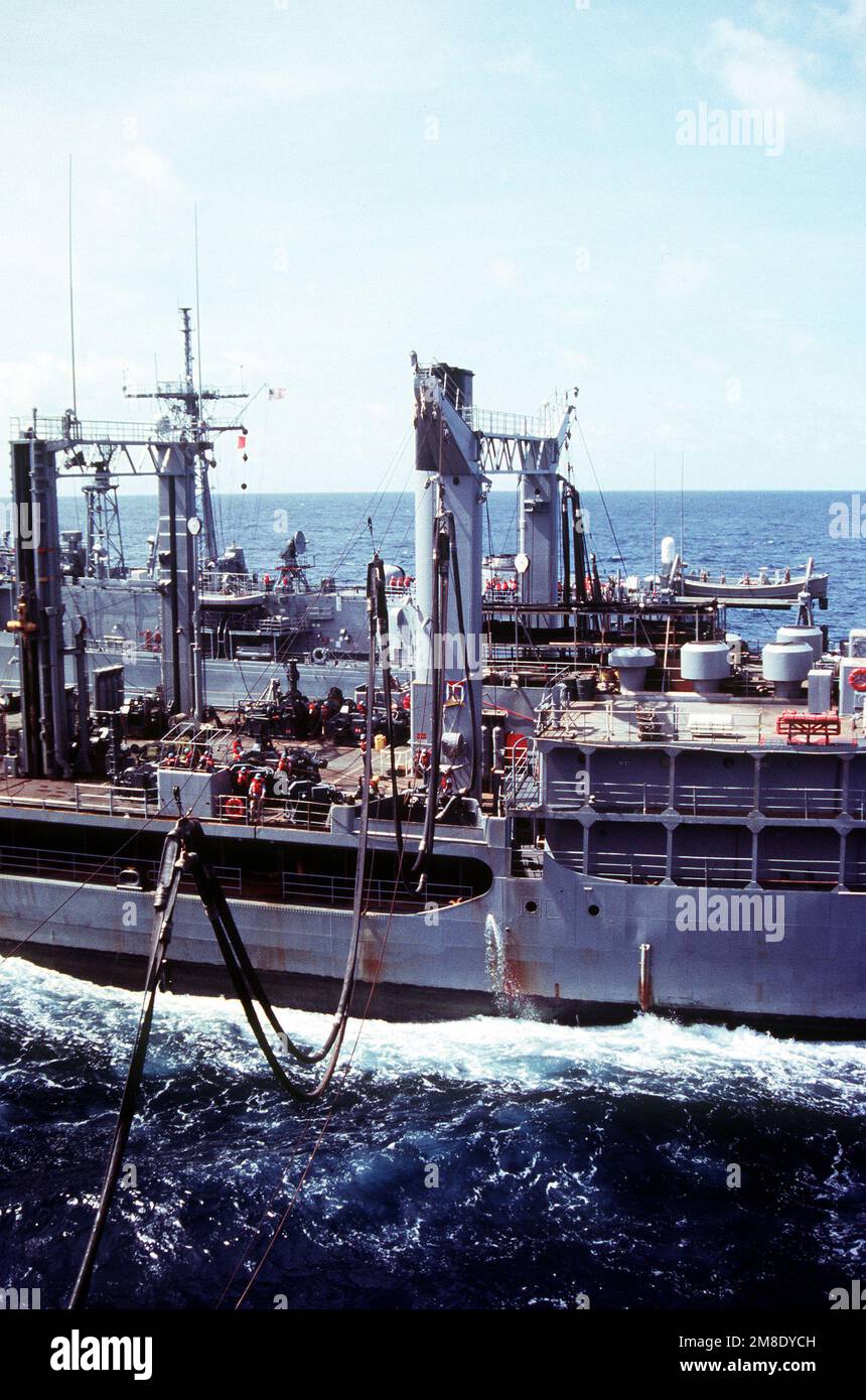 Refueling hoses extend from another ship to the kingpost of the fleet ...