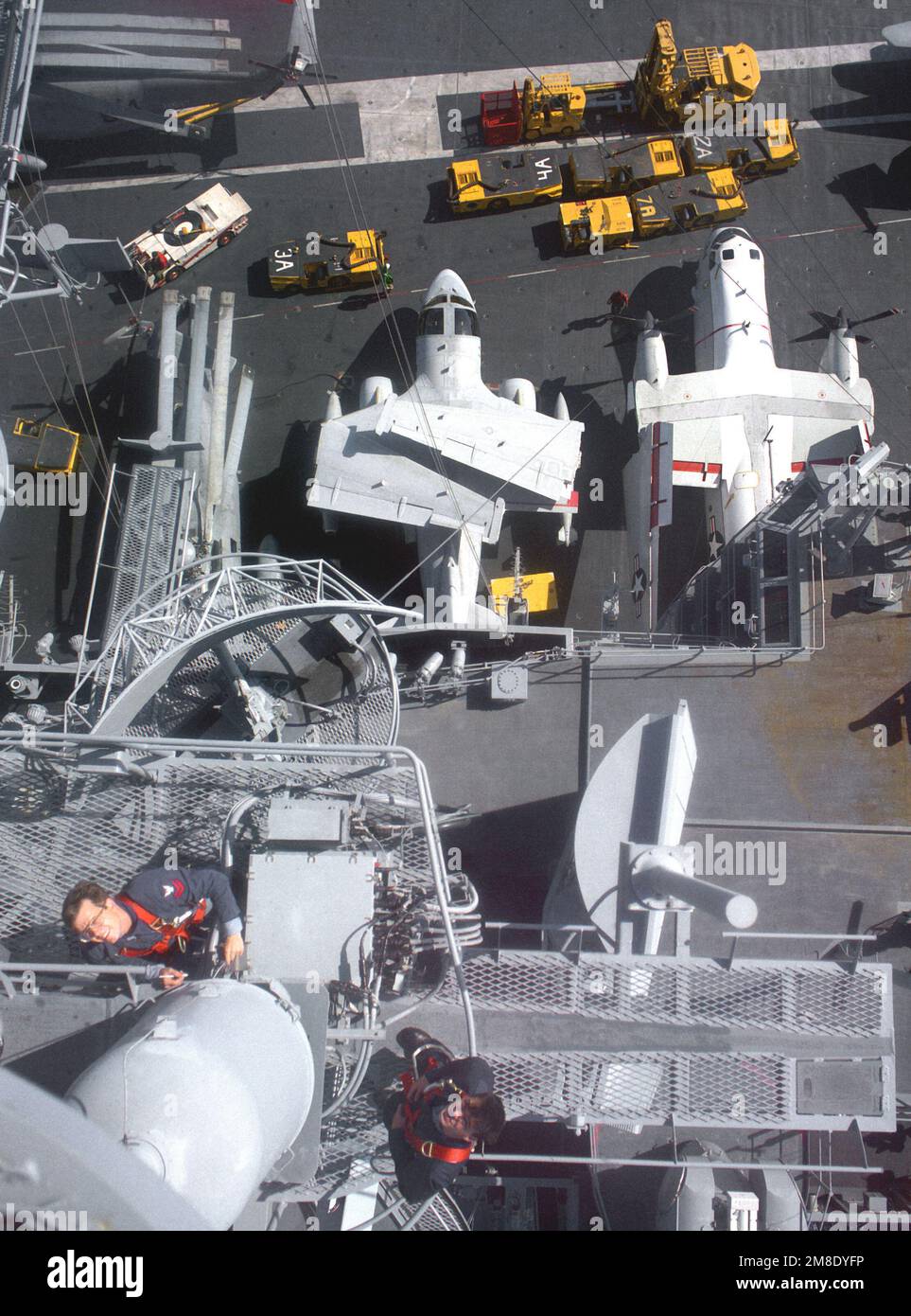 Crew Members Look Up From Their Task Of Securing A Radar Dome Aboard