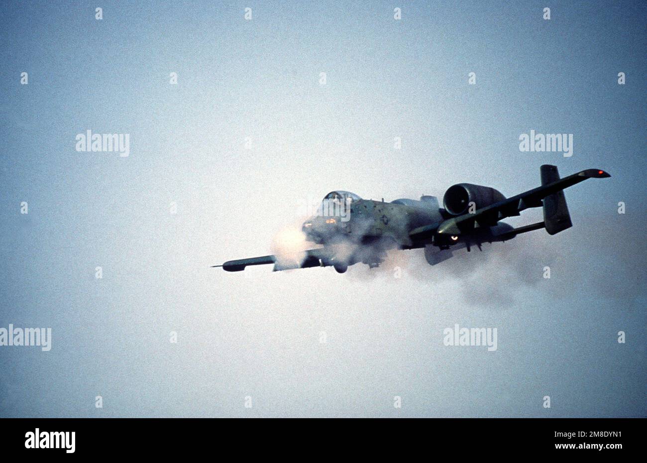 An A-10A Thunderbolt aircraft fires its GAU-8/A 30mm cannon at a target ...