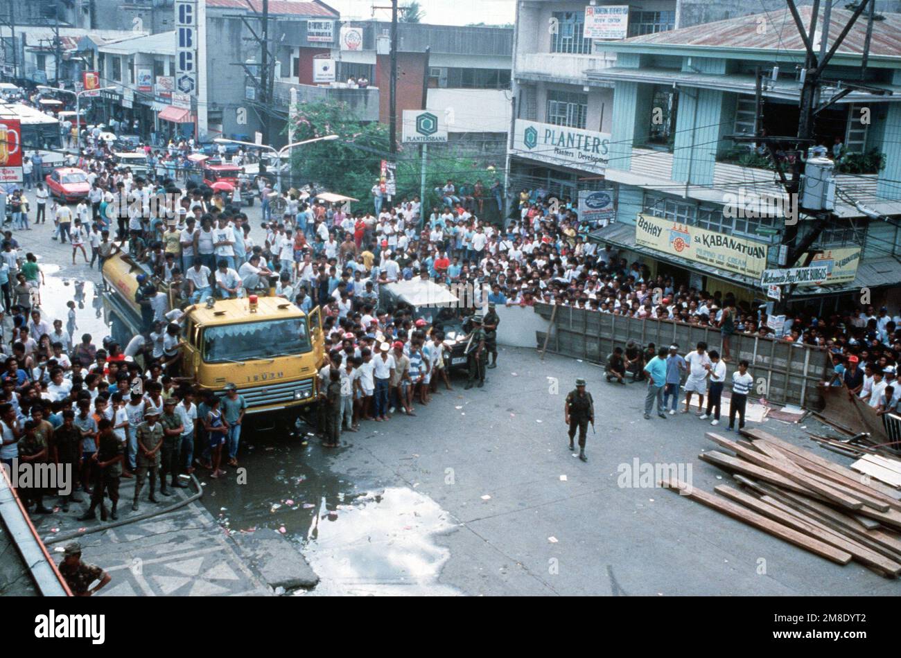 A crowd gathers during rescue efforts in an area which was devastated ...