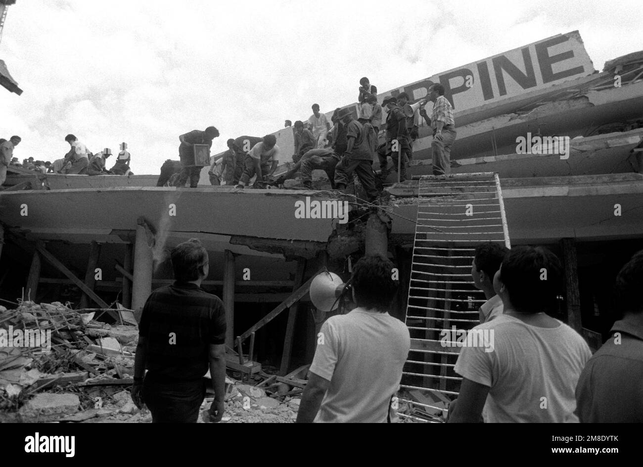 Rescue workers, assisted by members of a United States Marine ...