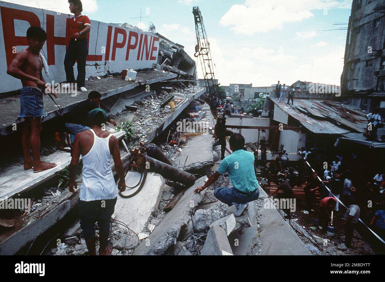 Rescue workers stand atop devastated buildings at the Christian College ...