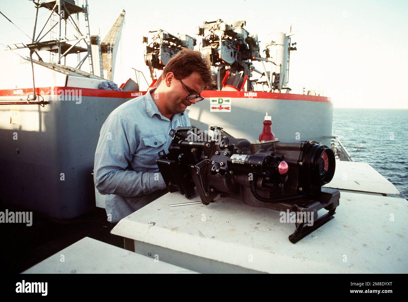 A sailor aboard the amphibious transport dock USS RALEIGH (LPD-1) works ...
