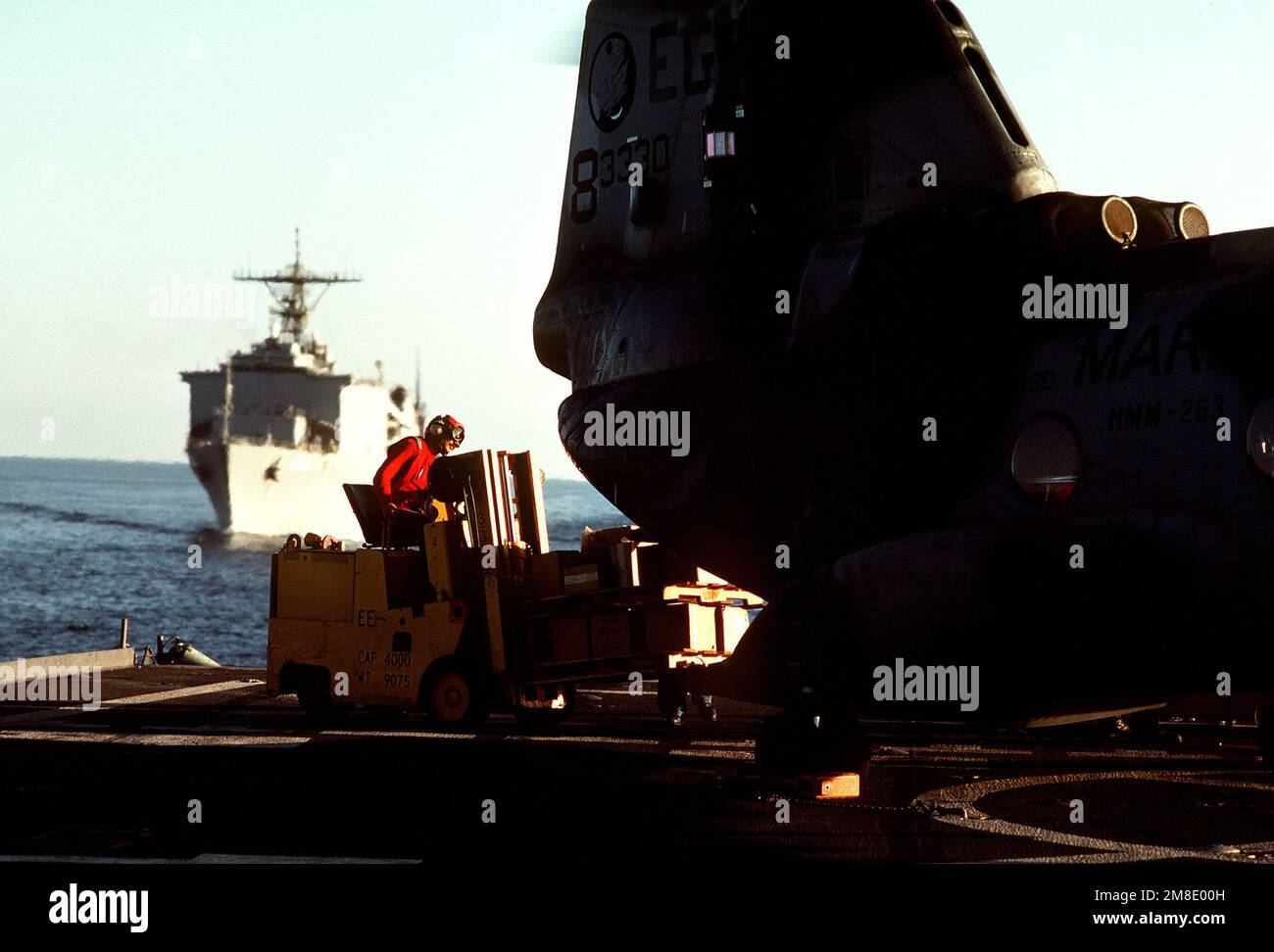 A flight deck crewman uses a forklift to load cargo onto a Marine ...