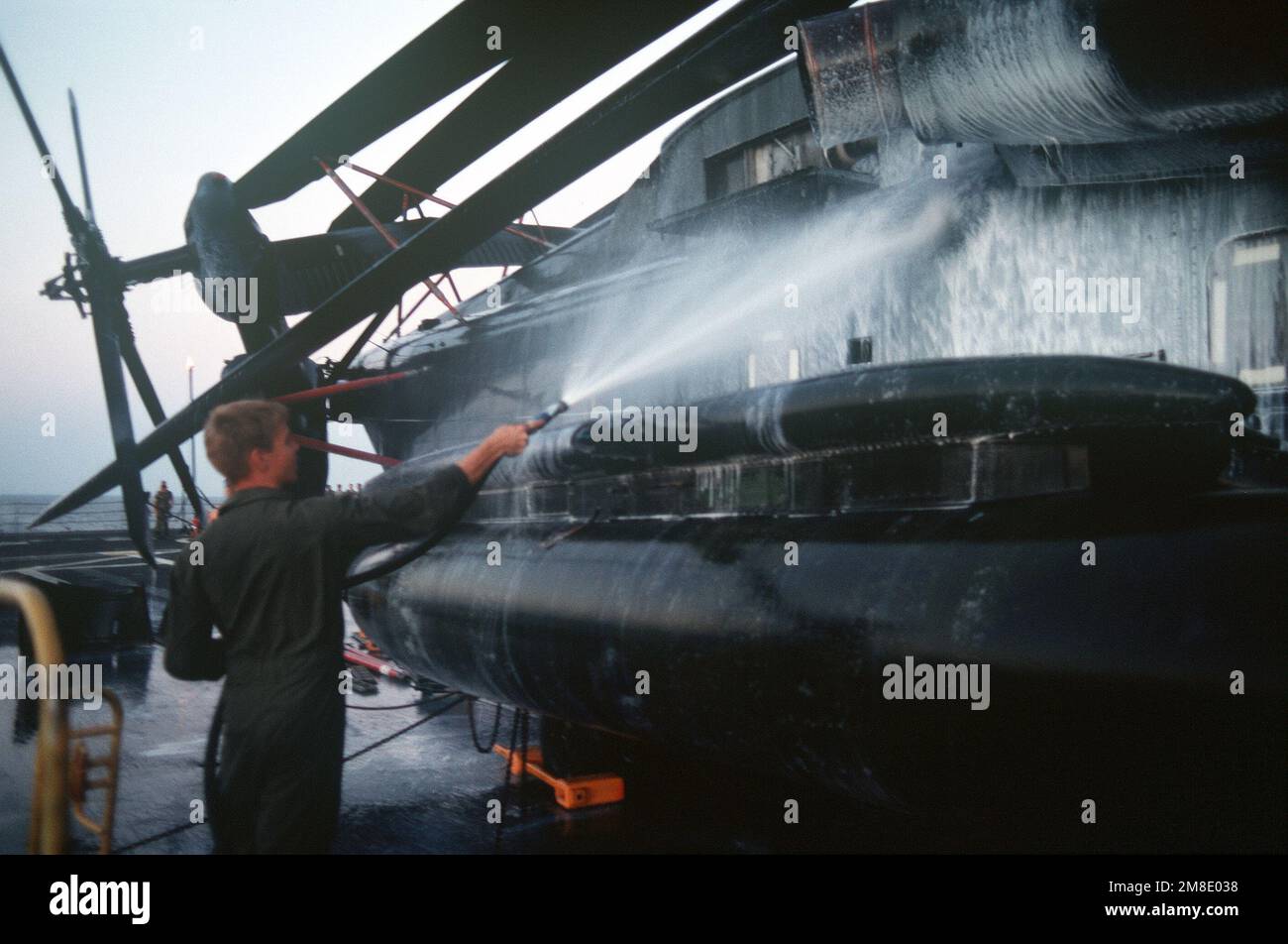 A Marine rinses soap off the side of a Marine Heavy Helicopter Squadron ...