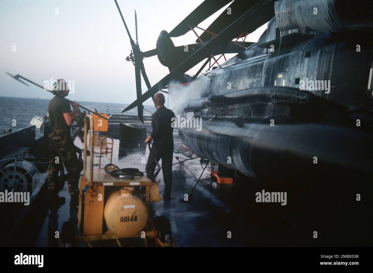 Two Marines complete a fresh-water washdown of a Marine Heavy ...