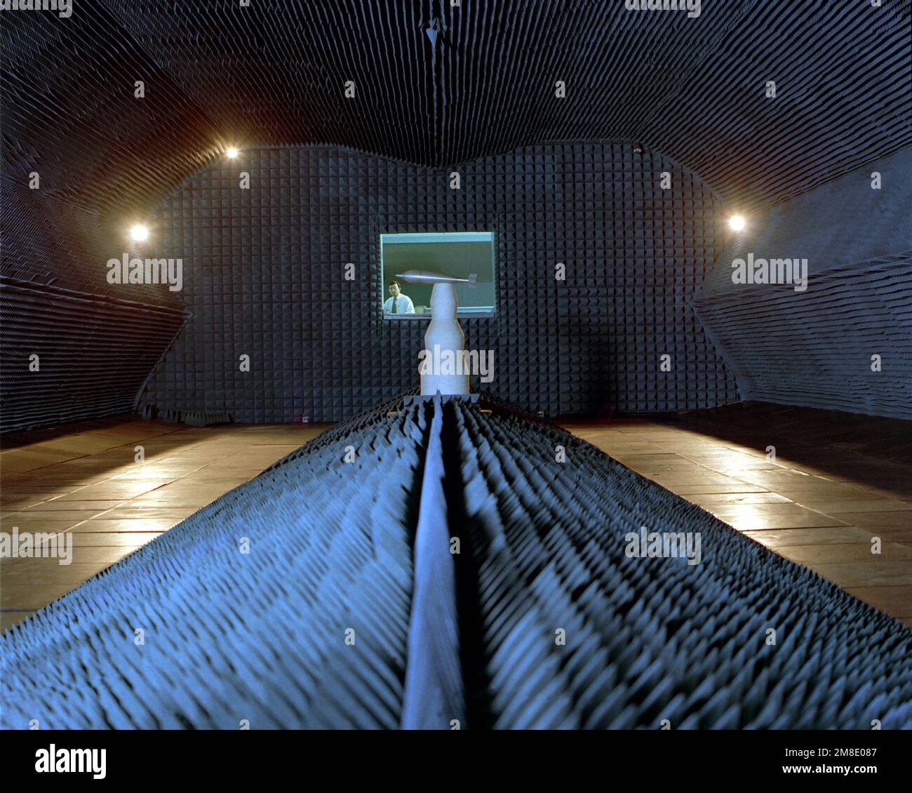 A technician looks into an anechoic chamber used for testing antennas ...