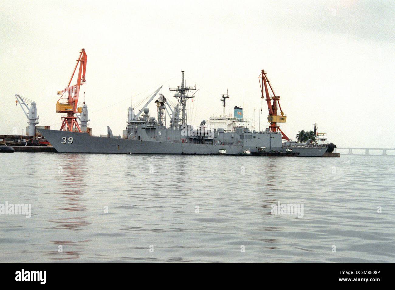 A port view of the guided missile frigate USS DOYLE (FFG-39) tied to a ...