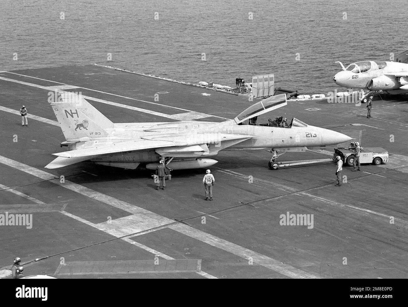 An MD-3A tow tractor positions a Fighter Squadron 213 (VF-213) F-14A ...