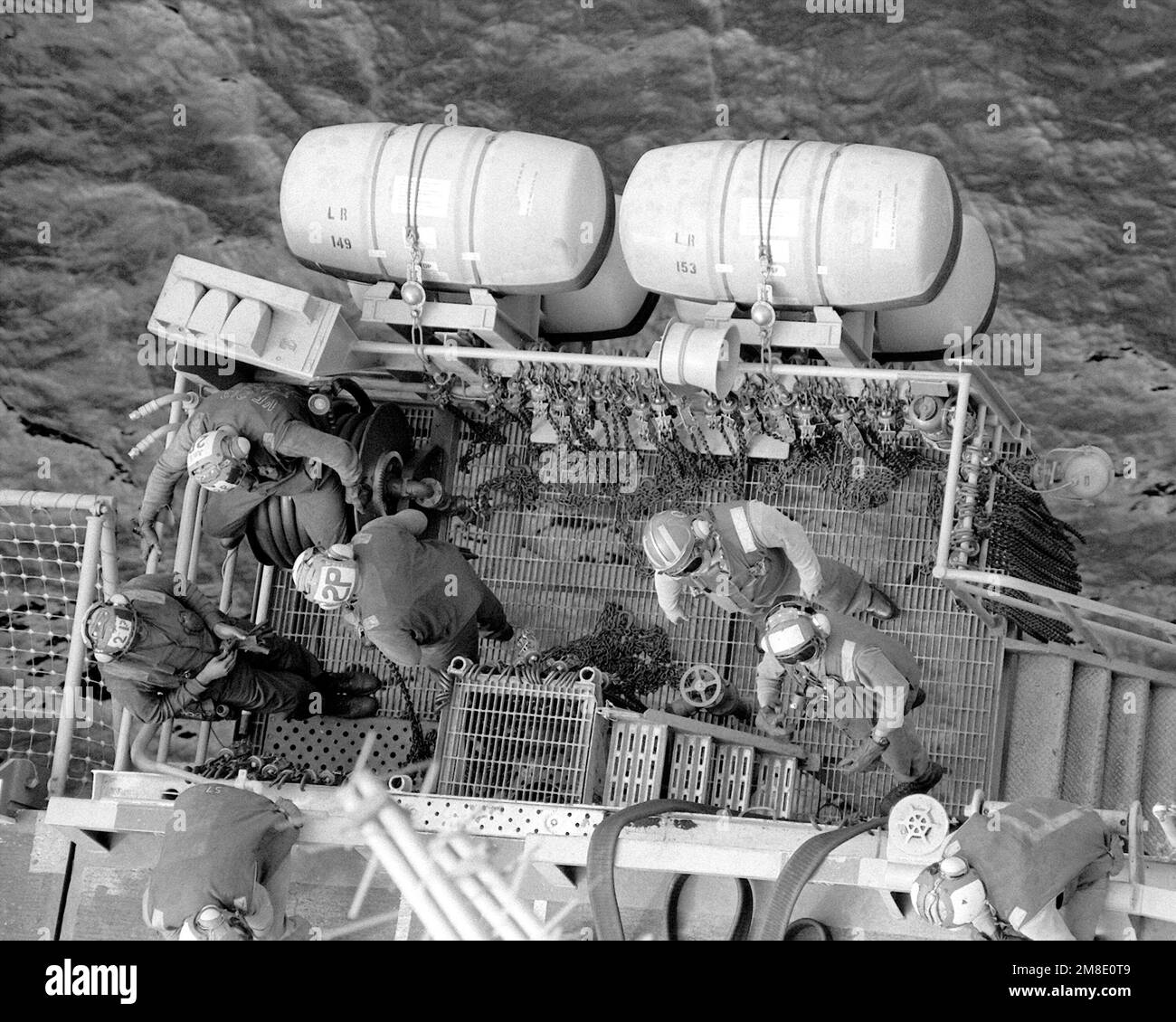 Flight deck crew members maintain their station on an outboard catwalk ...