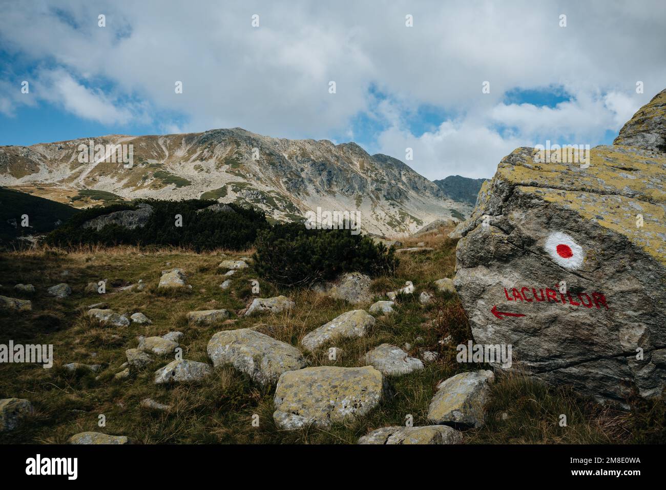 A red Romanian sign means "lake" on a rock with direction arrow in ...