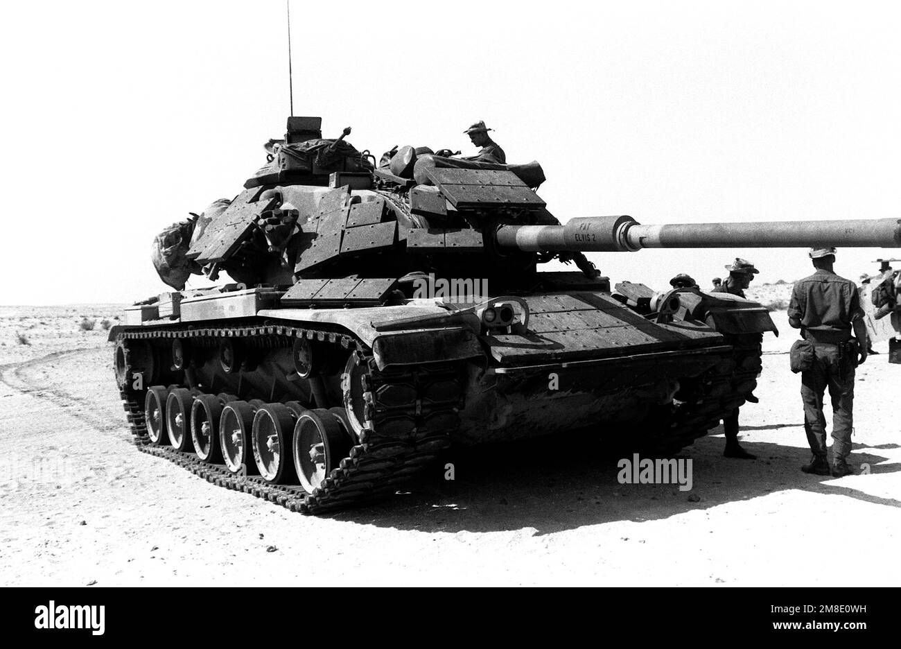 Marines gather beside an M-60A1 main battle tank fitted with reactive armor during Operation ...