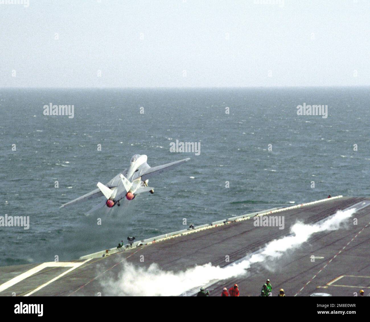 A Fighter Squadron 114 (VF-114) F-14A Tomcat aircraft banks to the left ...