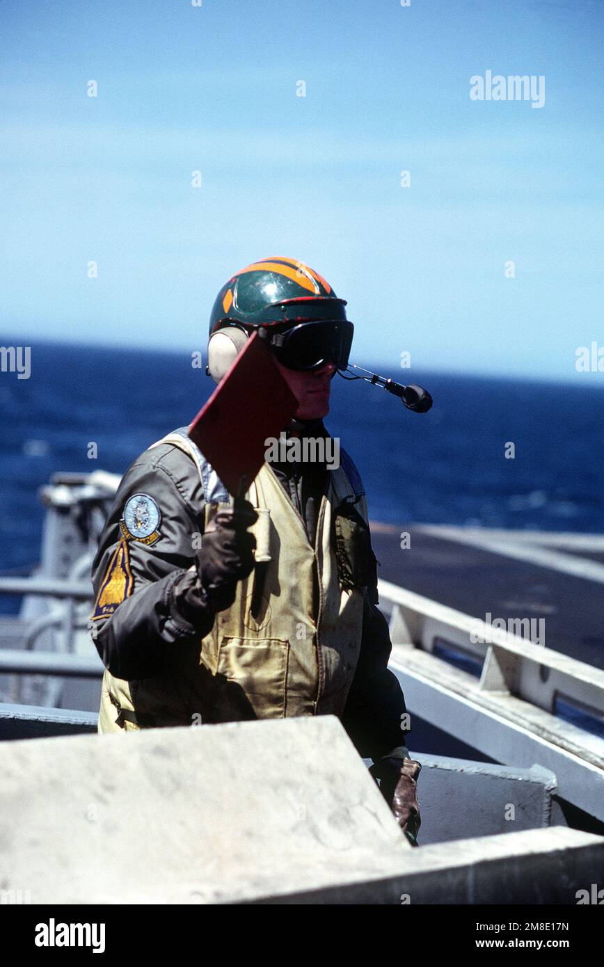 A landing signal officer (LSO) of Fighter Squadron 213 (VF-213) uses ...
