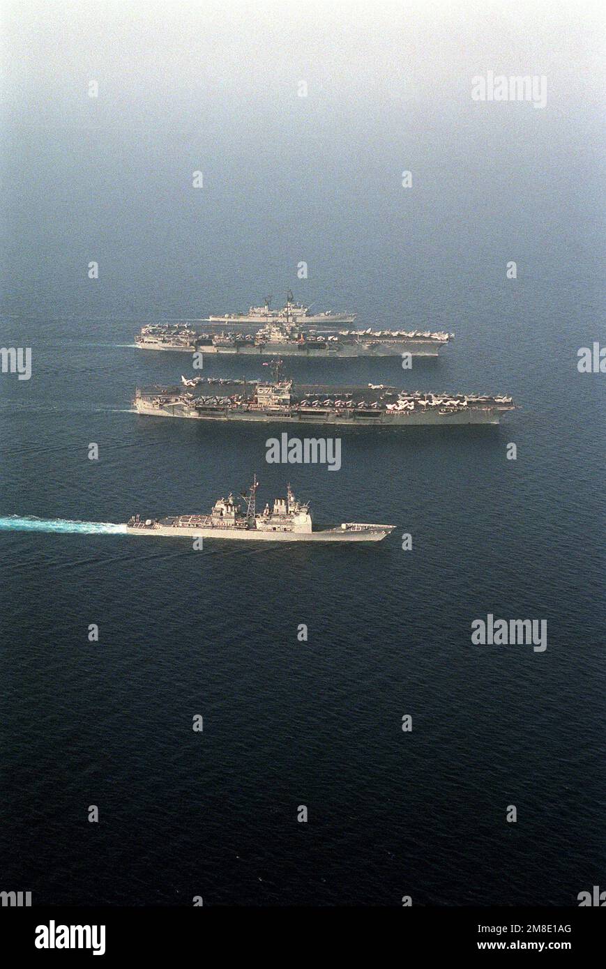 An aerial view of, from bottom to top, the guided missile cruiser USS ...