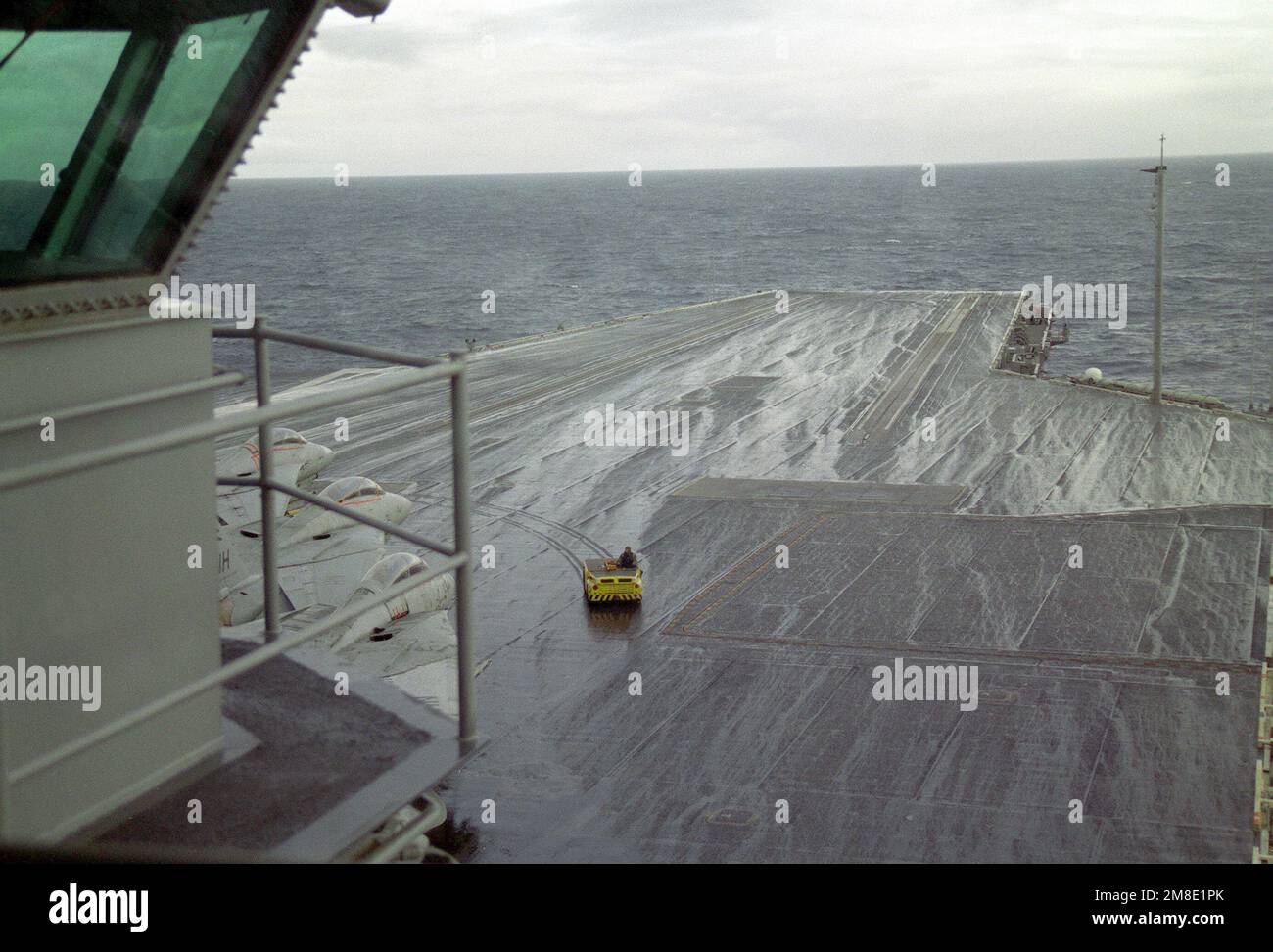 An MD-3A tow tractor leaves tracks as rain and wind produce an icy ...