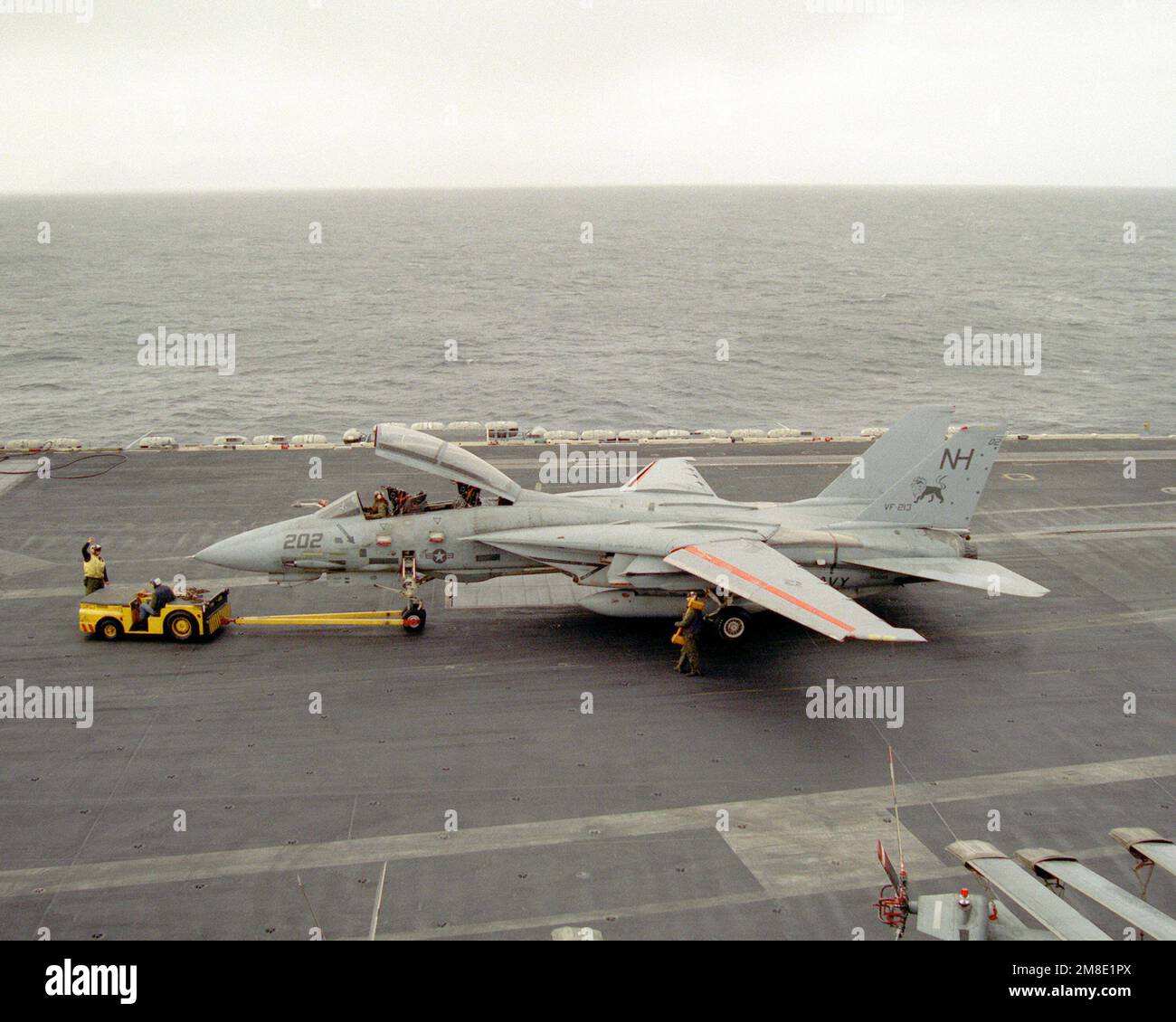 An MD-3A tow tractor pulls a Fighter Squadron 213 (VF-213) F-14A Tomcat ...
