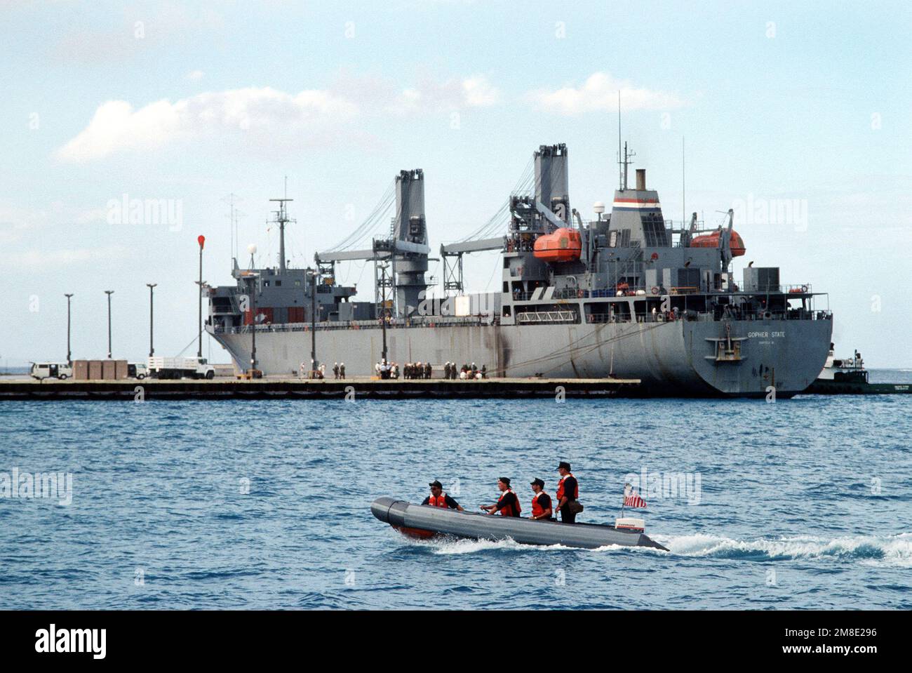 Coast Guardsmen aboard a rigid-hull inflatable boat pass through the ...