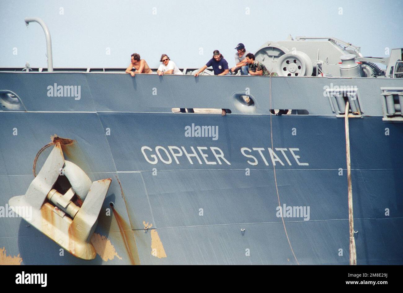 Crewmen aboard the Military Sealift Command auxiliary crane ship GOPHER ...