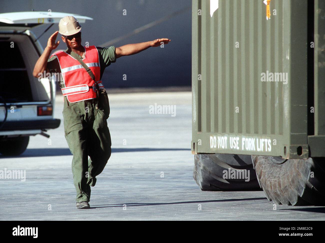 A soldier from the 155th Transportation Company guides the driver of a ...
