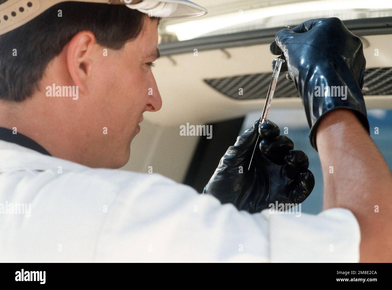Paul Lewis, a civilian contractor, prepares a solution while checking a ...