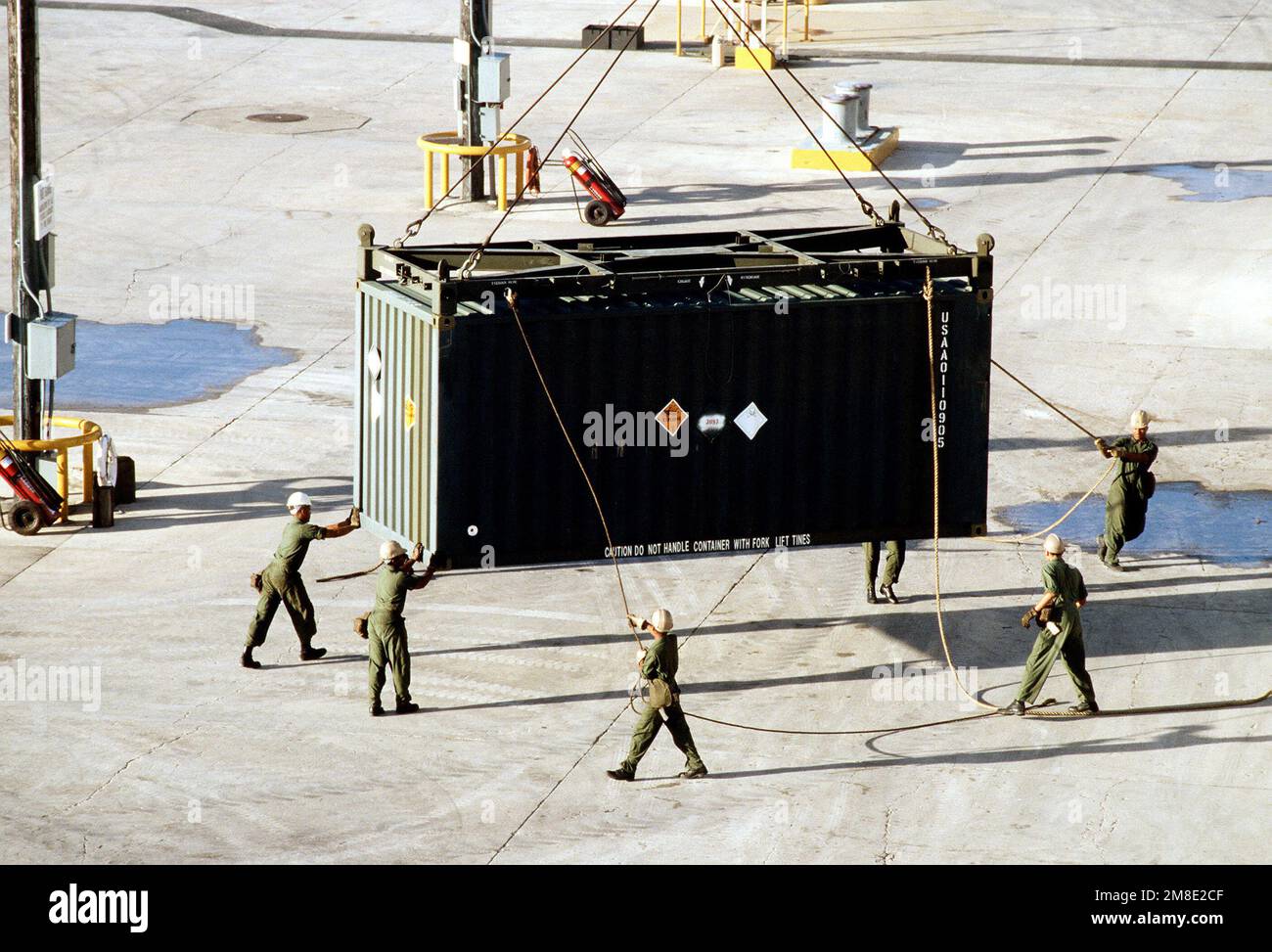 A container of chemical munitions is lowered to the pier after being ...