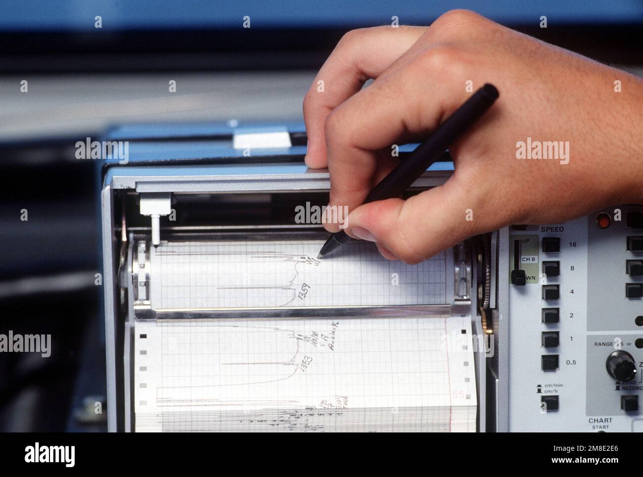 A civilian contractor makes a notation on the printout from an ...