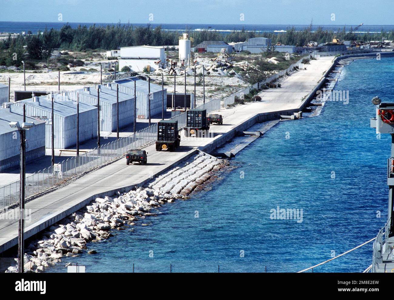 Two trucks carrying containers of chemical munitions are escorted by a ...