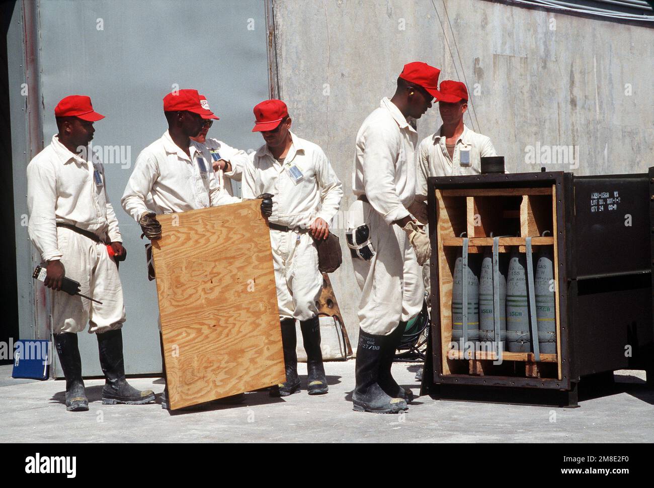 Soldiers prepare to unload a crate of 155mm chemical artillery shells ...