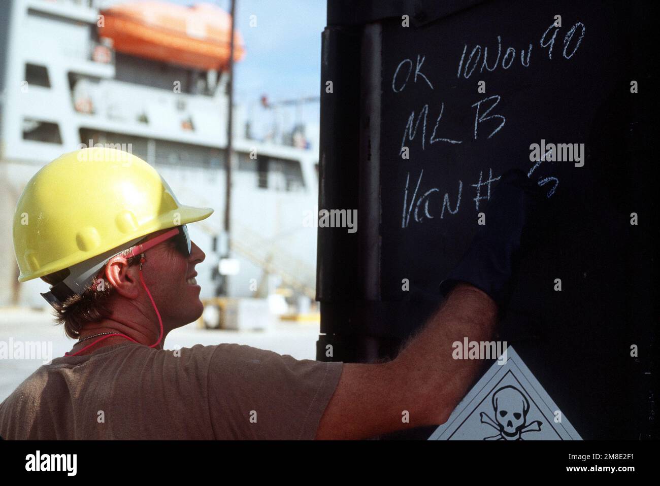 Michael Cobb, a civilian contractor, marks a container of chemical ...