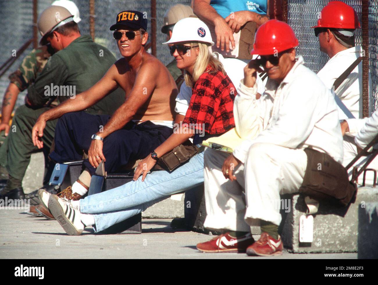 Civilian contractors and military personnel take a break while working ...