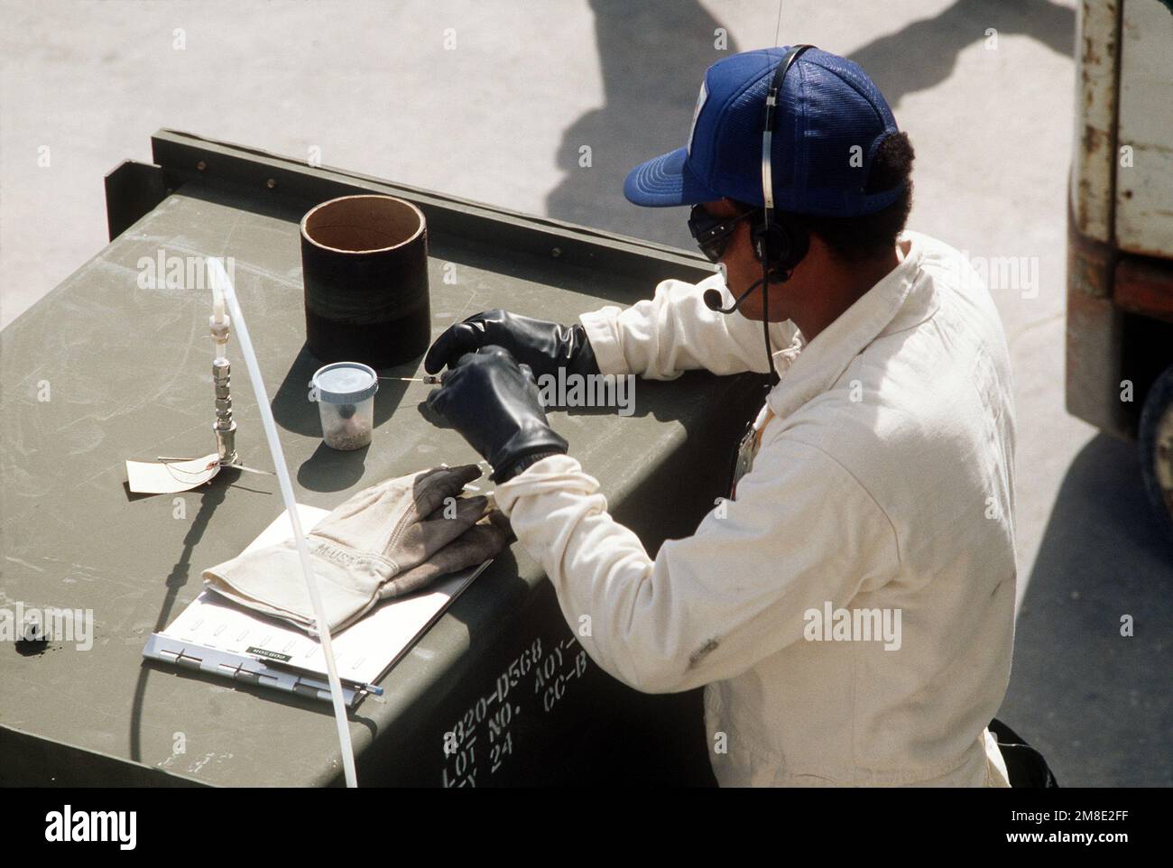 A civilian contractor checks an air sample taken from crate of of ...