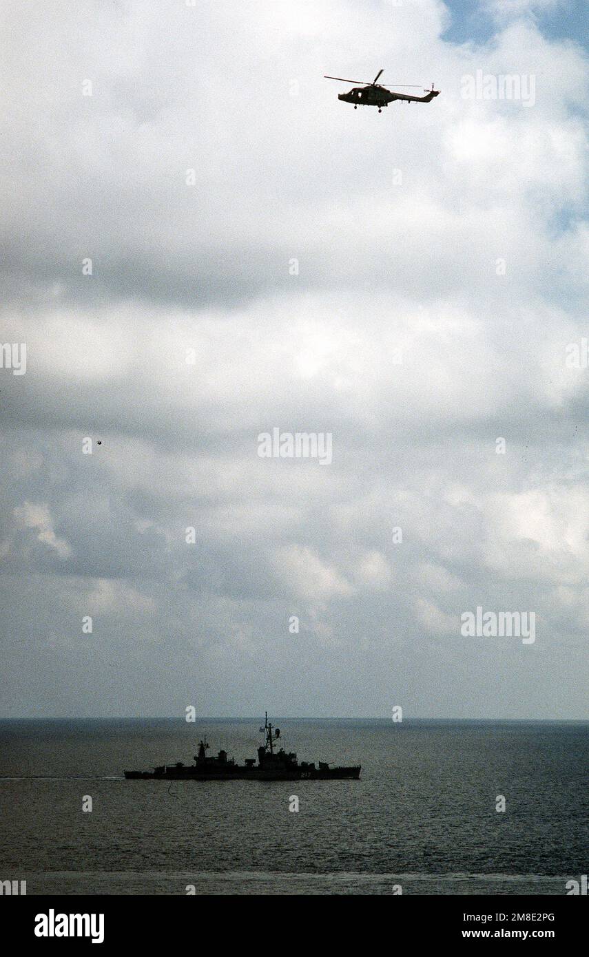 A Lynx helicopter of the Royal Navy flies over the Greek destroyer HS ...