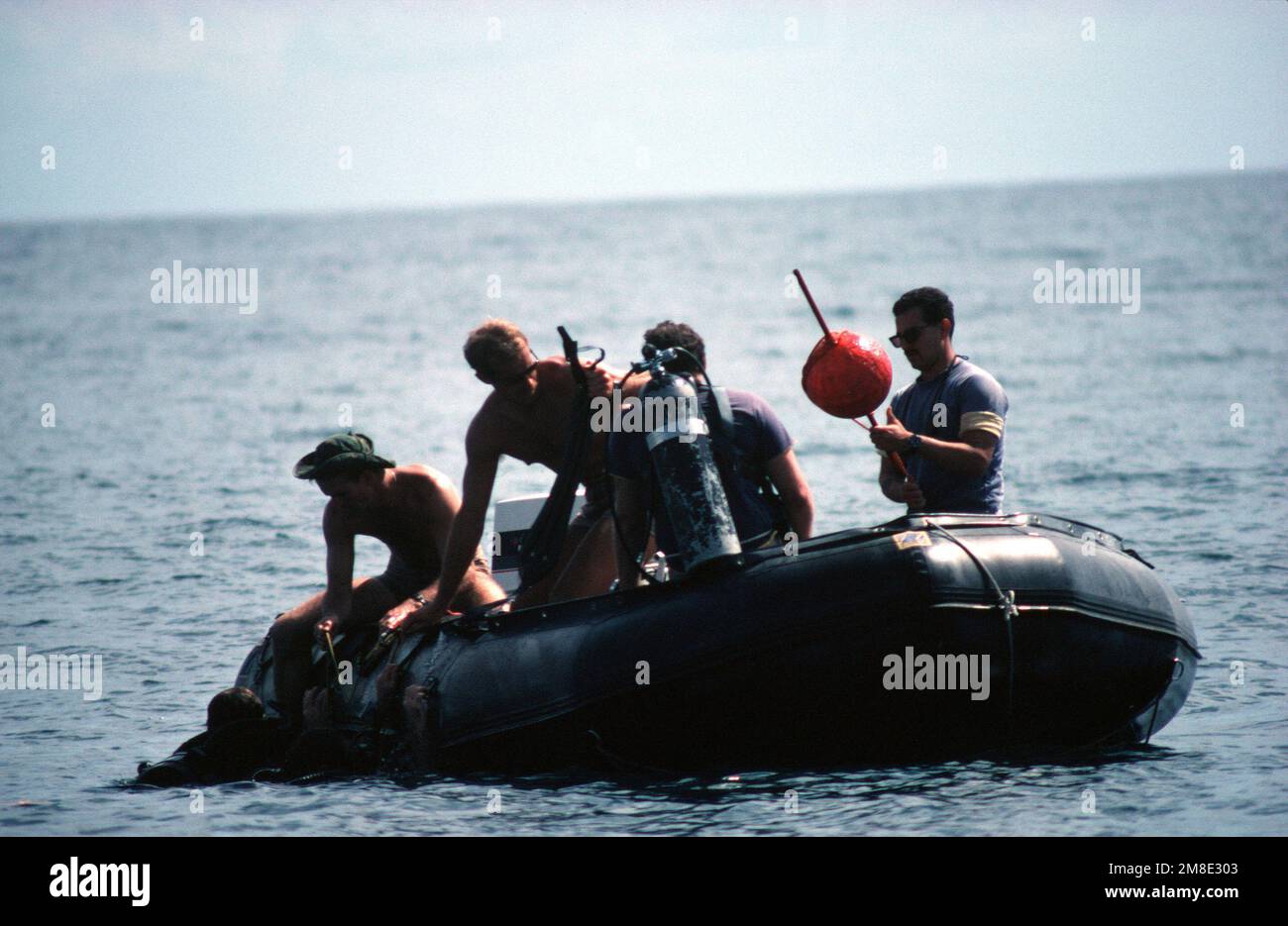 A member of an explosive ordnance disposal (EOD) diving support team ...
