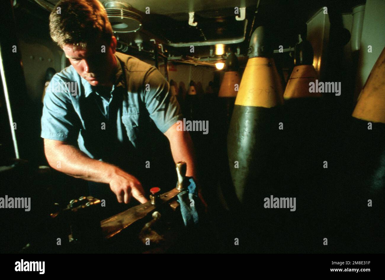 A Sailor Cleans A Piece Of Equipment In The Magazine Of One Of The Mark