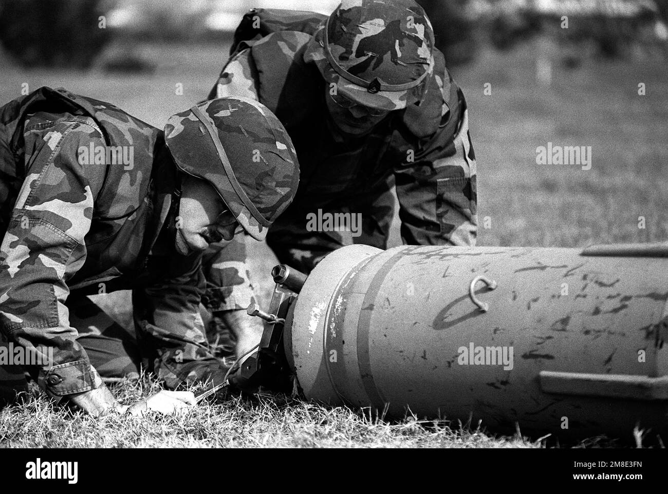 Two members of an Explosive Ordnance Disposal (EOD) unit disarm a ...